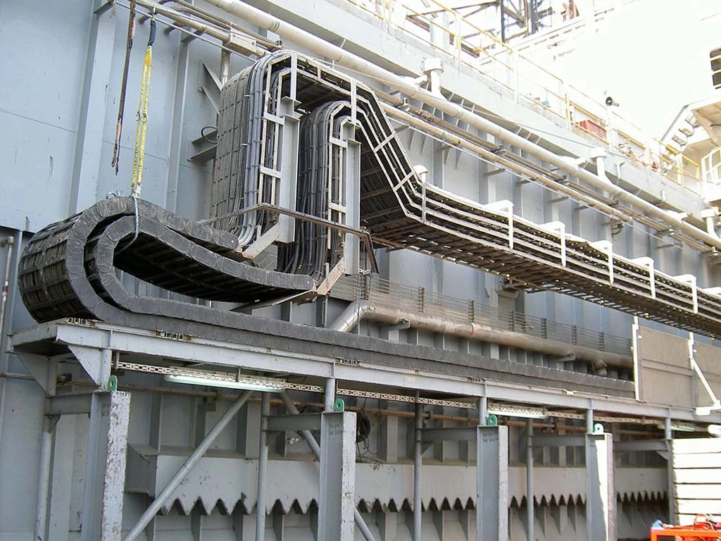 Robust energy chain moves cable for drill floor skid on drill ships